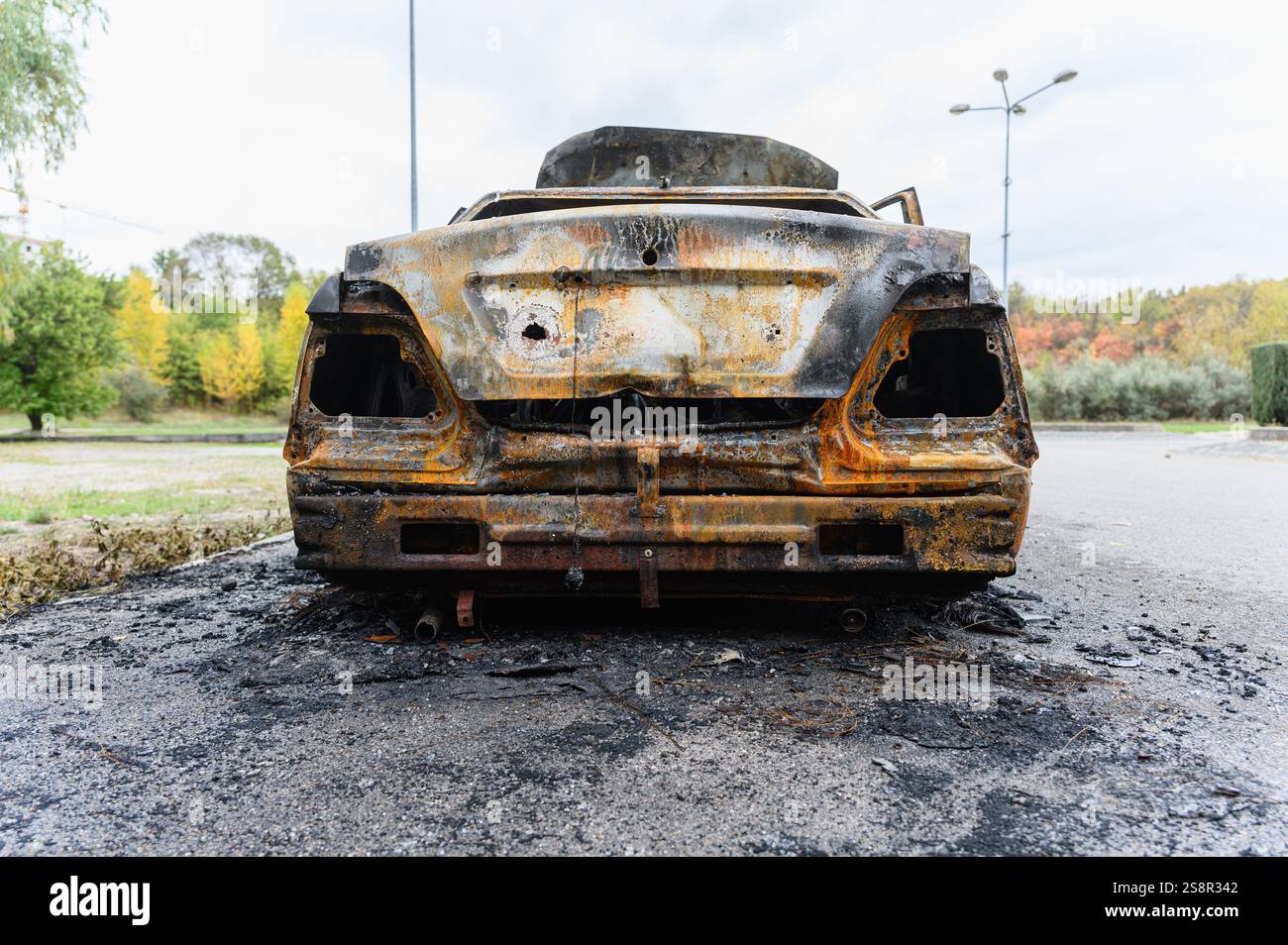 Burned car wreck abandoned on roadside in nature Stock Photo - Alamy