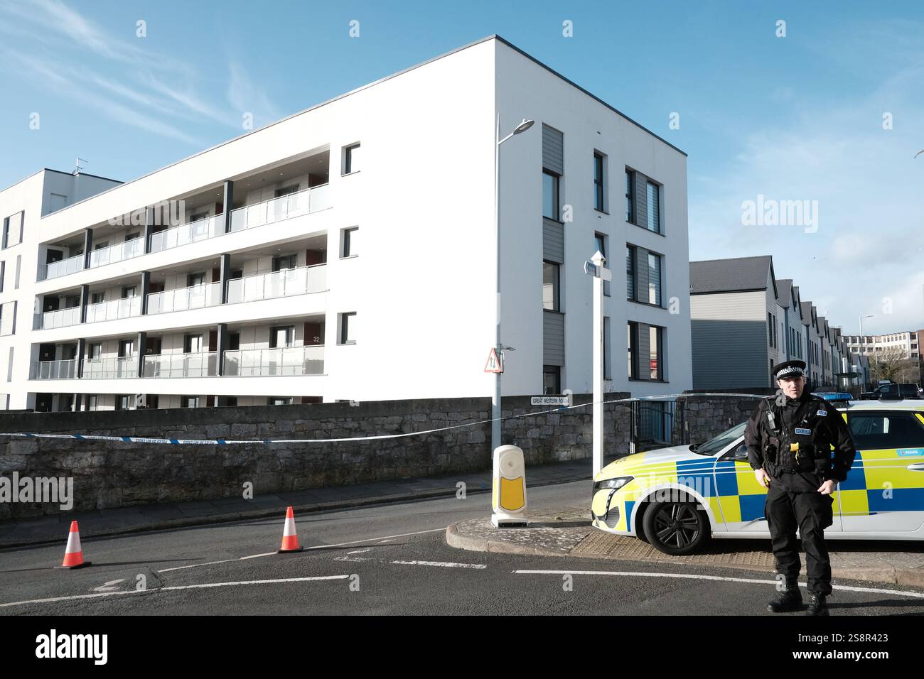 A police officer stands outside a block of flats at a scene in Plymouth ...