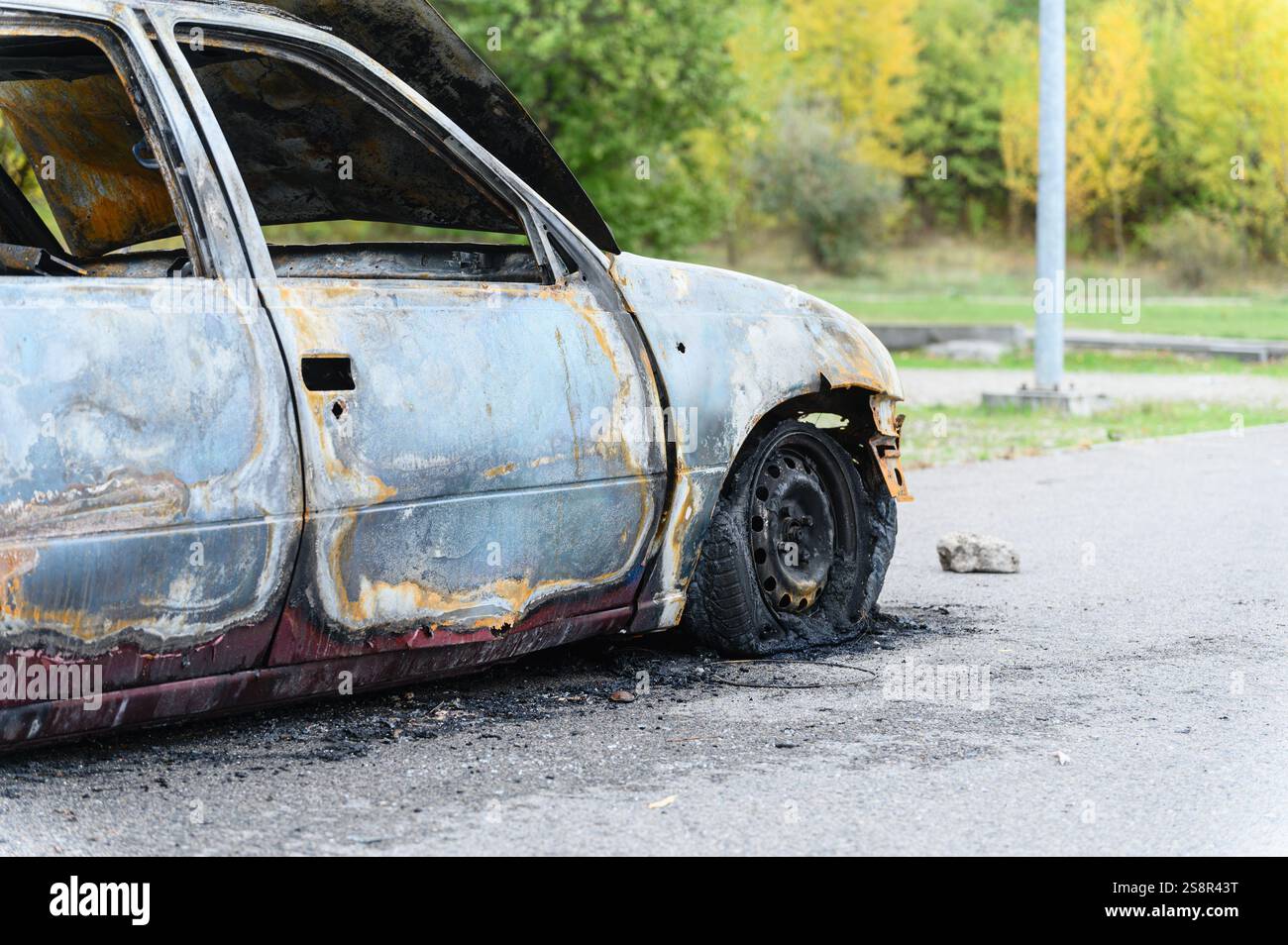 Burned car wreck abandoned on roadside in nature Stock Photo - Alamy