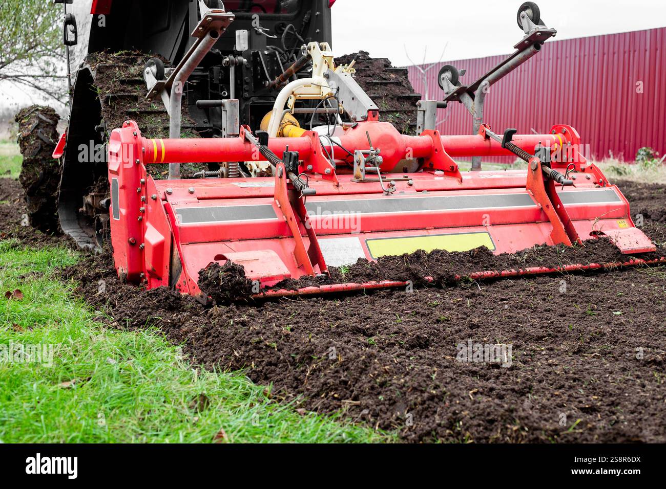 Plowing and milling the land on a garden plot. A crawler tractor with a ...