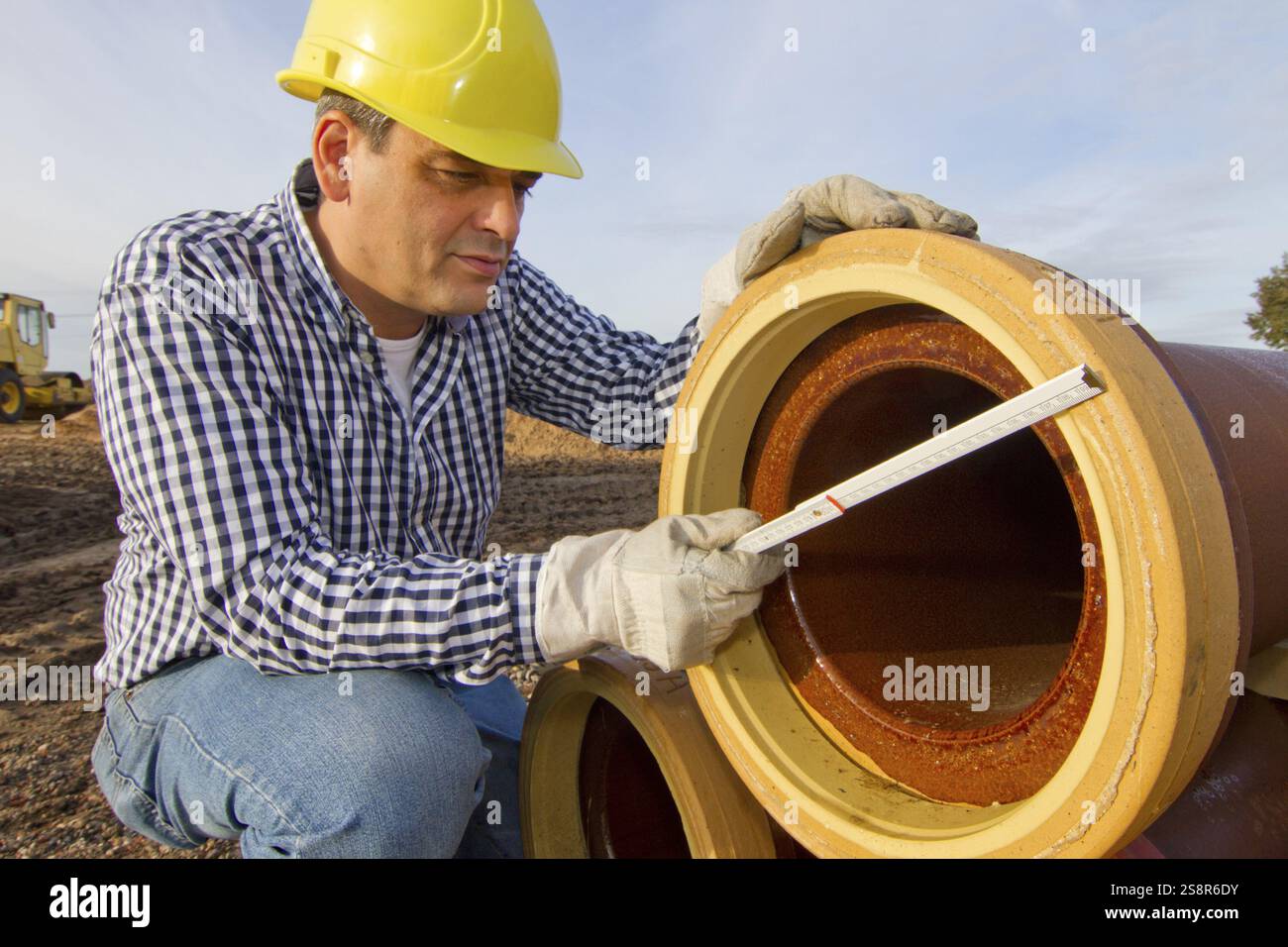 A construction worker checks a sewage pipe, craft, craftsman, pipe ...