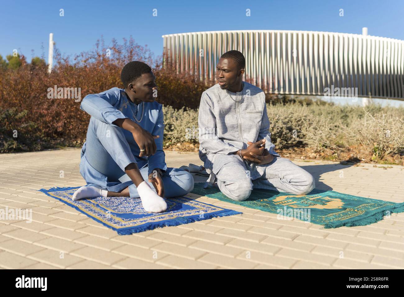 Two senegalese men wearing traditional clothing engage in conversation ...