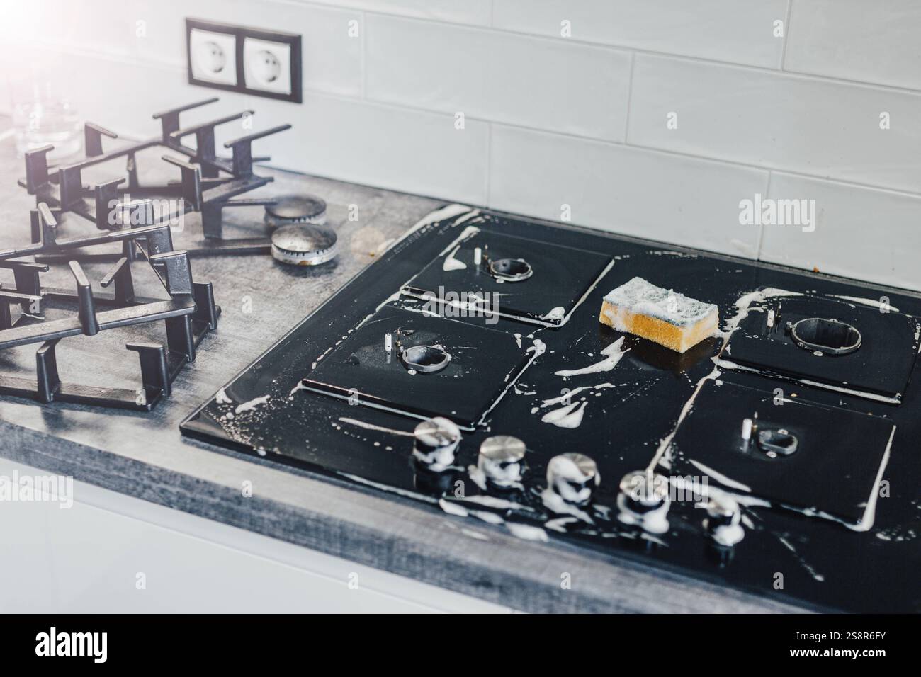 Industrial style kitchen with stove and cleaning sponge, soap applied ...