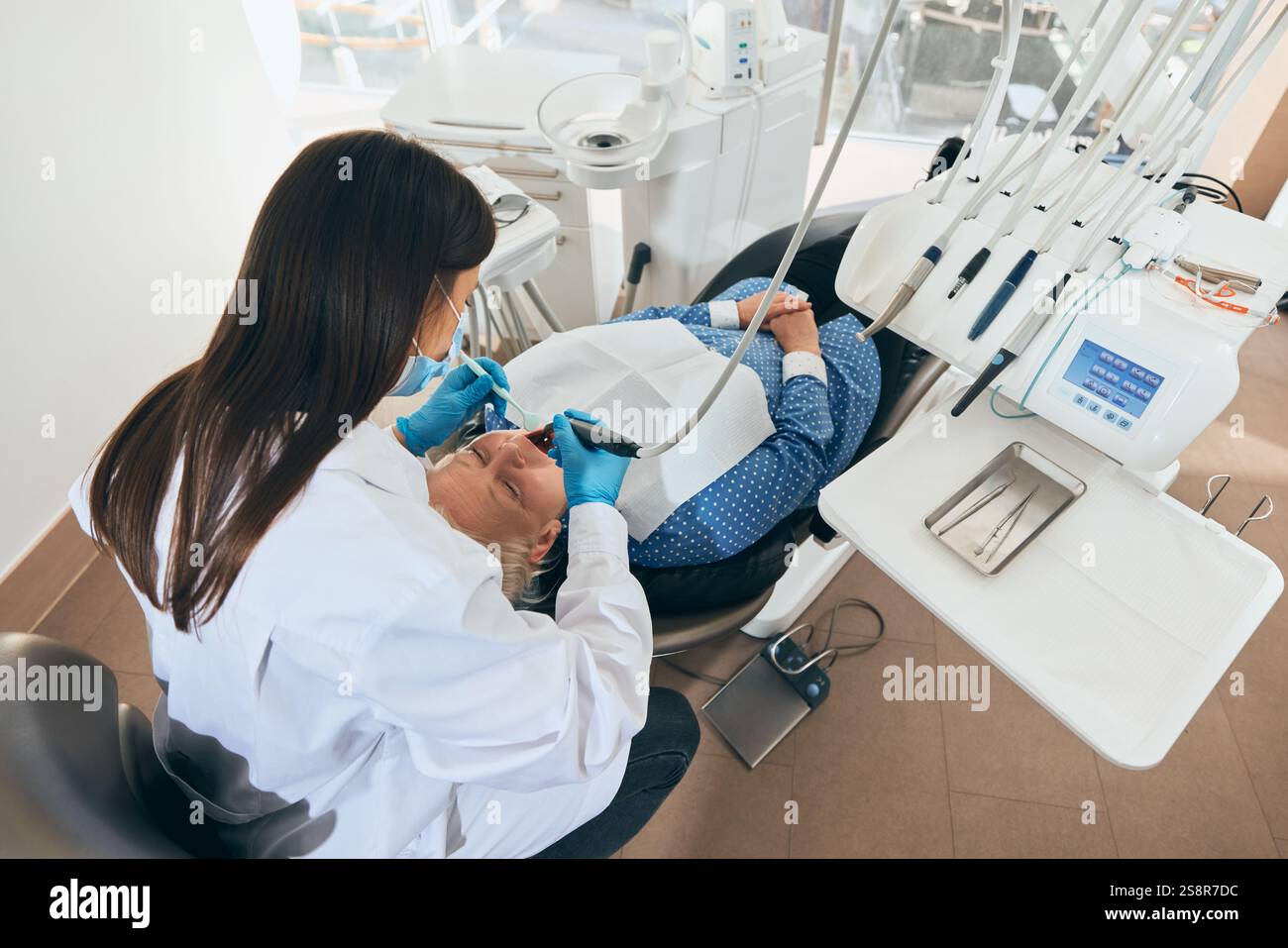 Top view of female doctor performing oral check-up on elderly patient ...