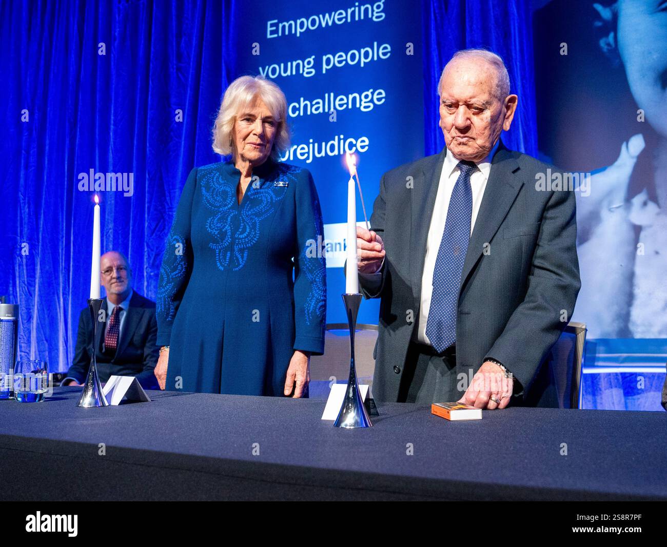Britain's Queen Camilla watches survivor Arem Hersch light a candle ...