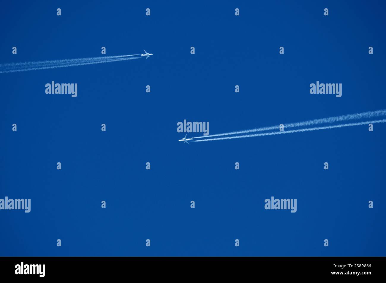 Airplane trails in the blue sky. Two airplanes in the sky, contrails ...