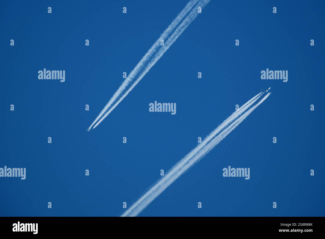 Airplane trails in the blue sky. Two airplanes in the sky, contrails ...