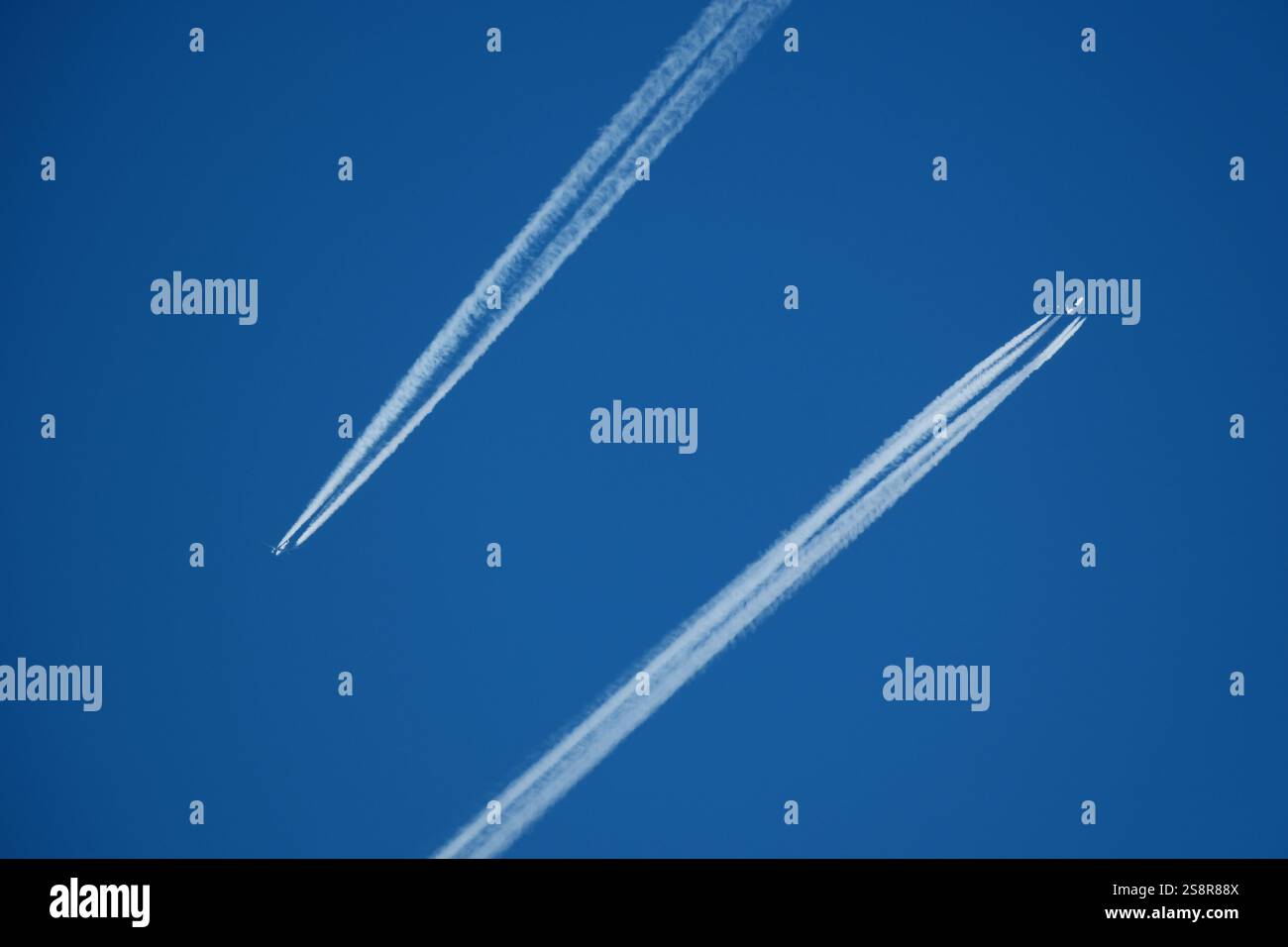 Airplane trails in the blue sky. Two airplanes in the sky, contrails ...