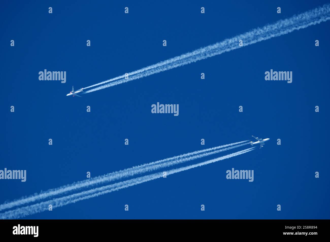 Airplane trails in the blue sky. Two airplanes in the sky, contrails ...