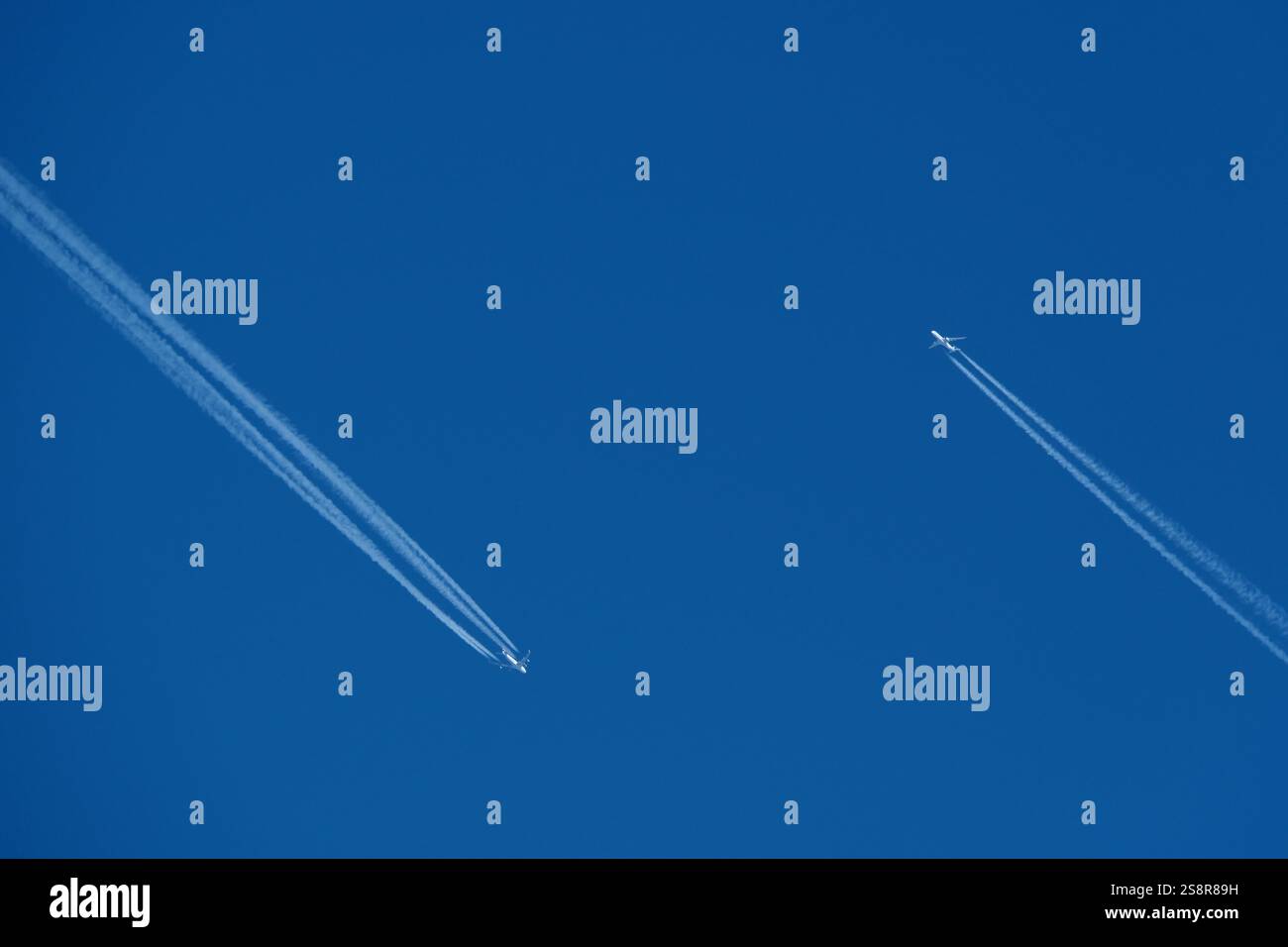 Airplane trails in the blue sky. Two airplanes in the sky, contrails ...