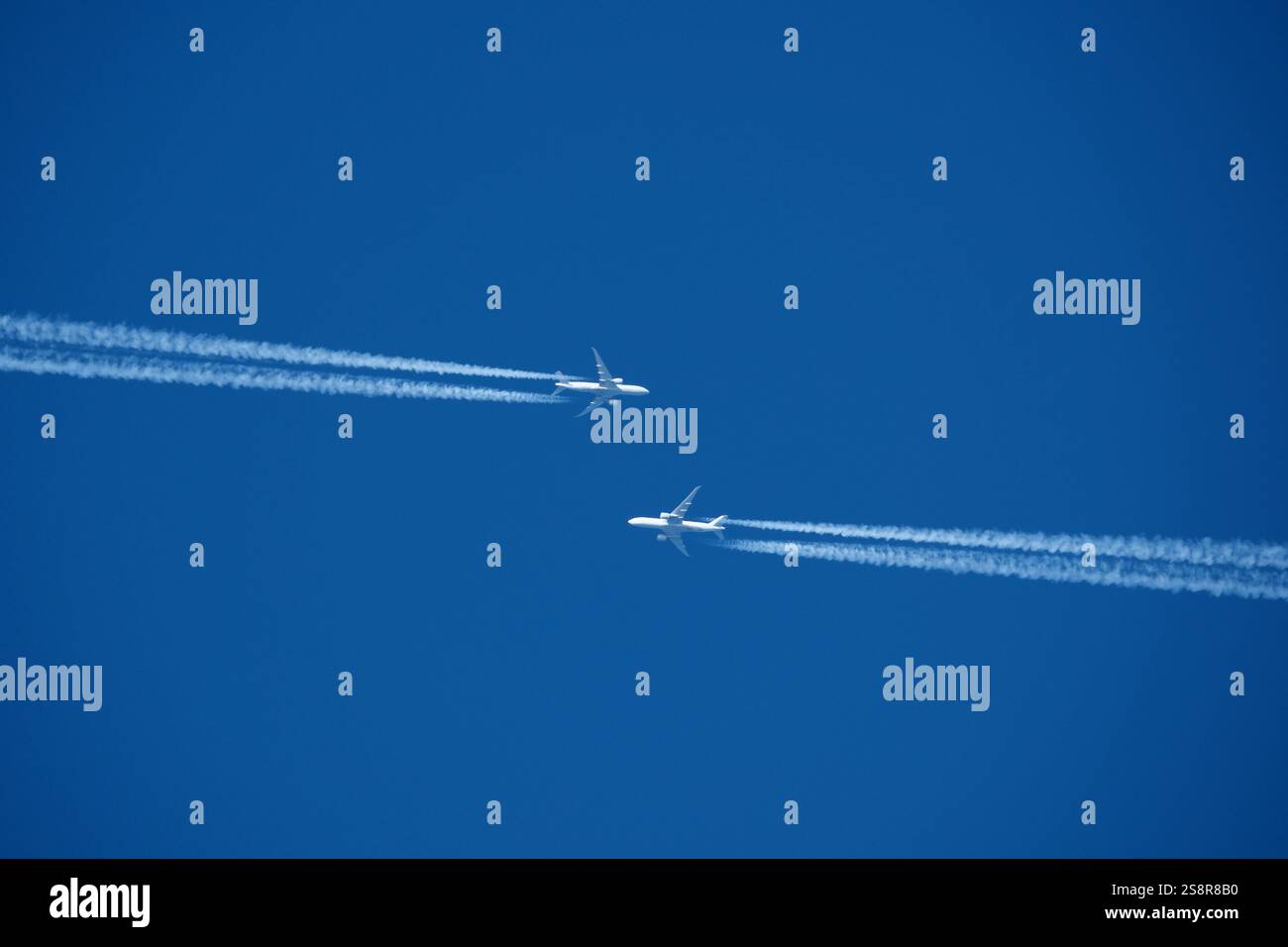 Airplane trails in the blue sky. Two airplanes in the sky, contrails ...