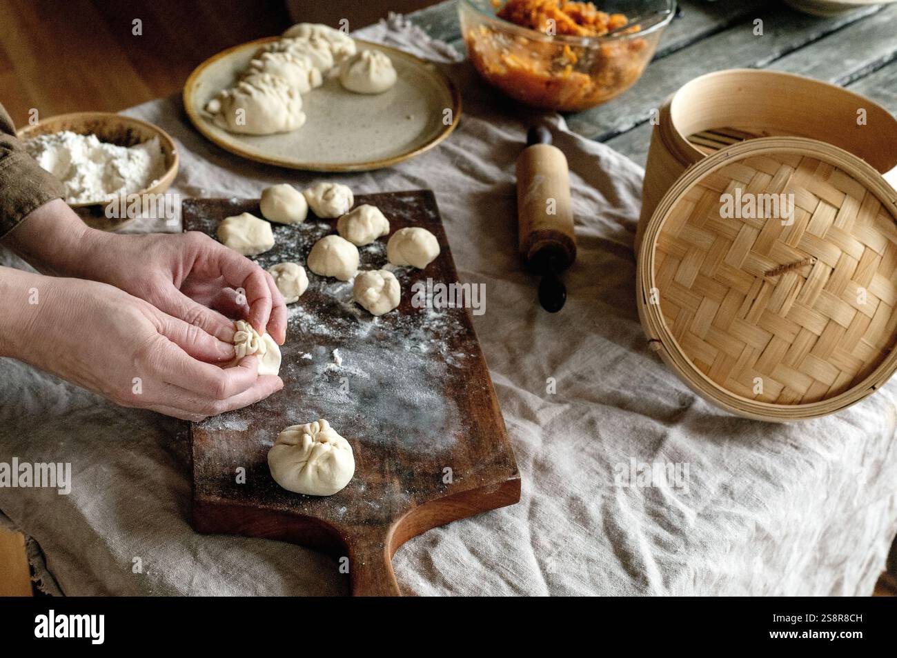 Making Asian steamed dumplings with vegetable filling. Female hands ...