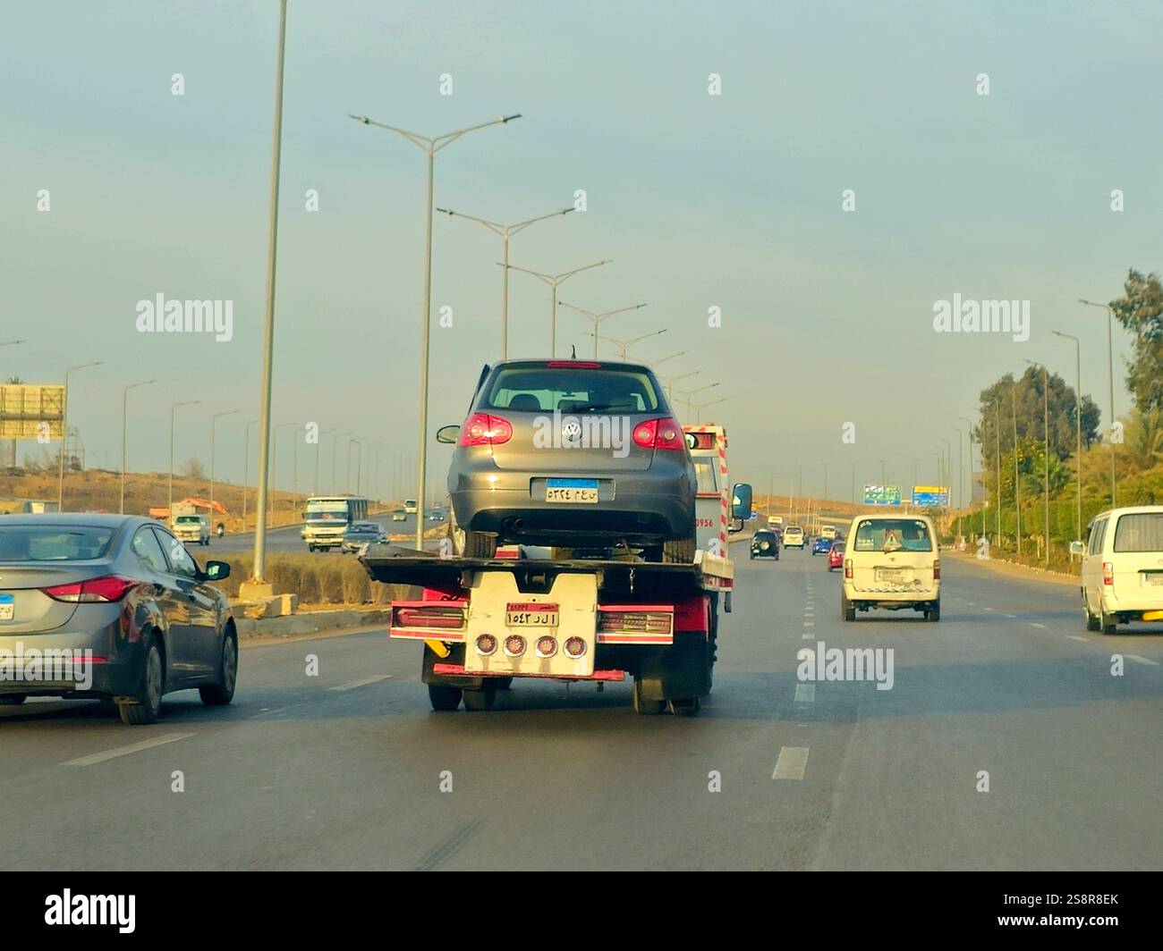 Cairo, Egypt, January 19 2025: A tow recovery transporter hydraulic flatbed truck moving a ...