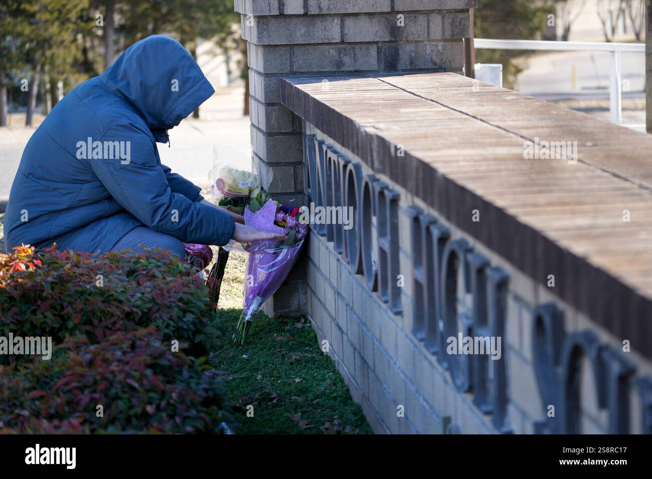 Jordan Hebert leaves flowers at a memorial for victims of a shooting at ...