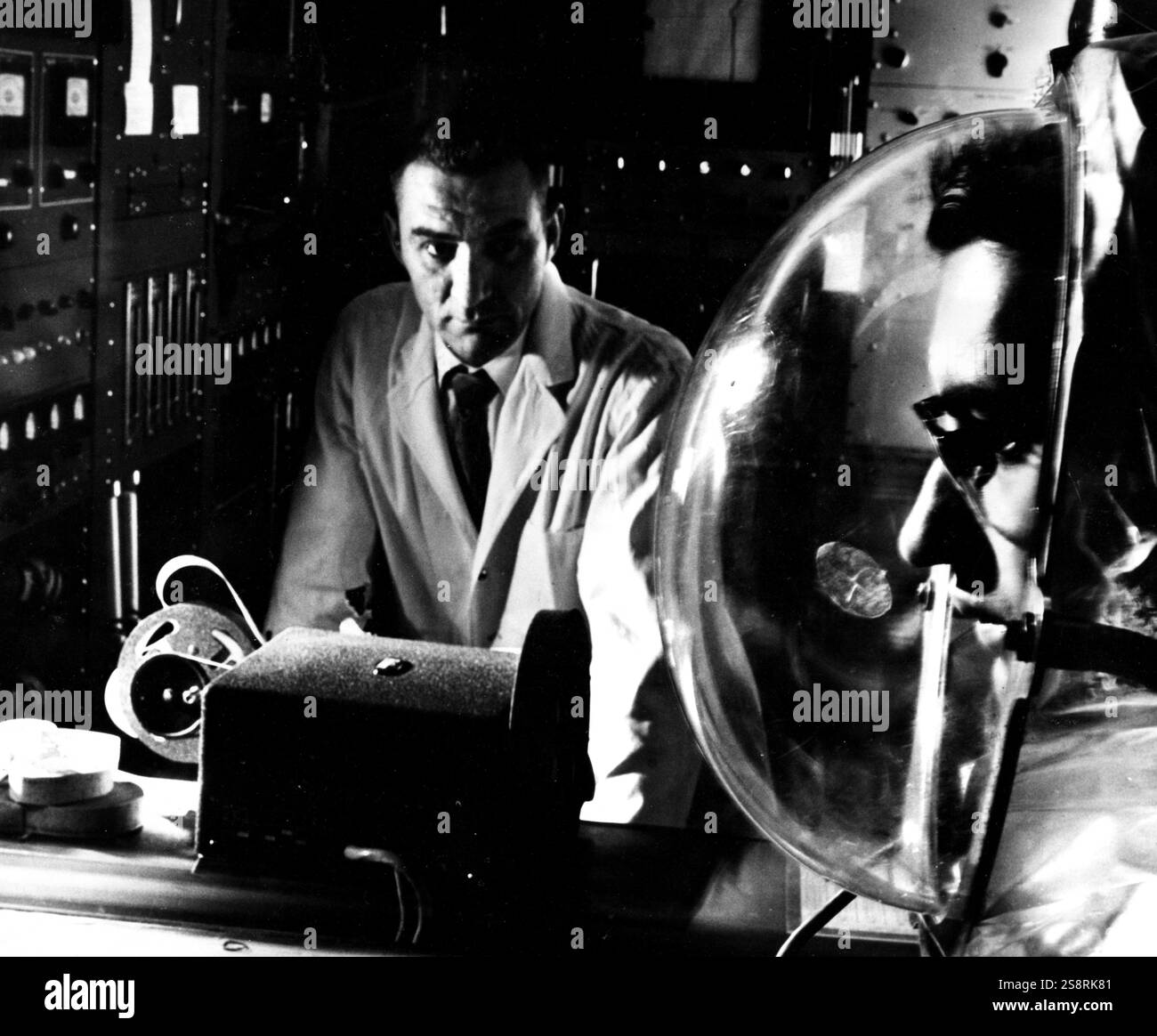 Photograph of a physicist monitoring a complex experiment using a ...