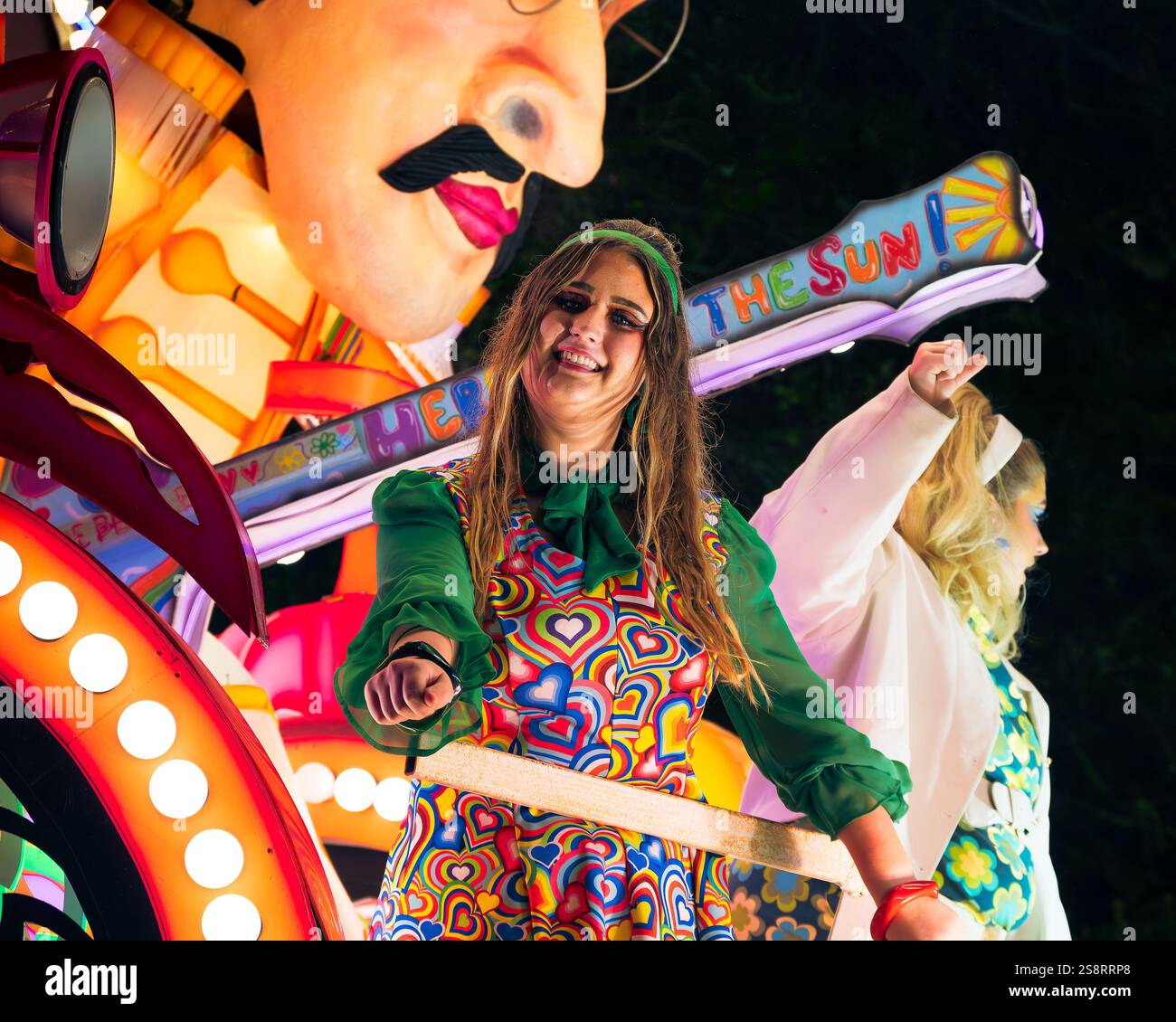 Happy carnival performer wearing a colorful retro 1960s costume ...