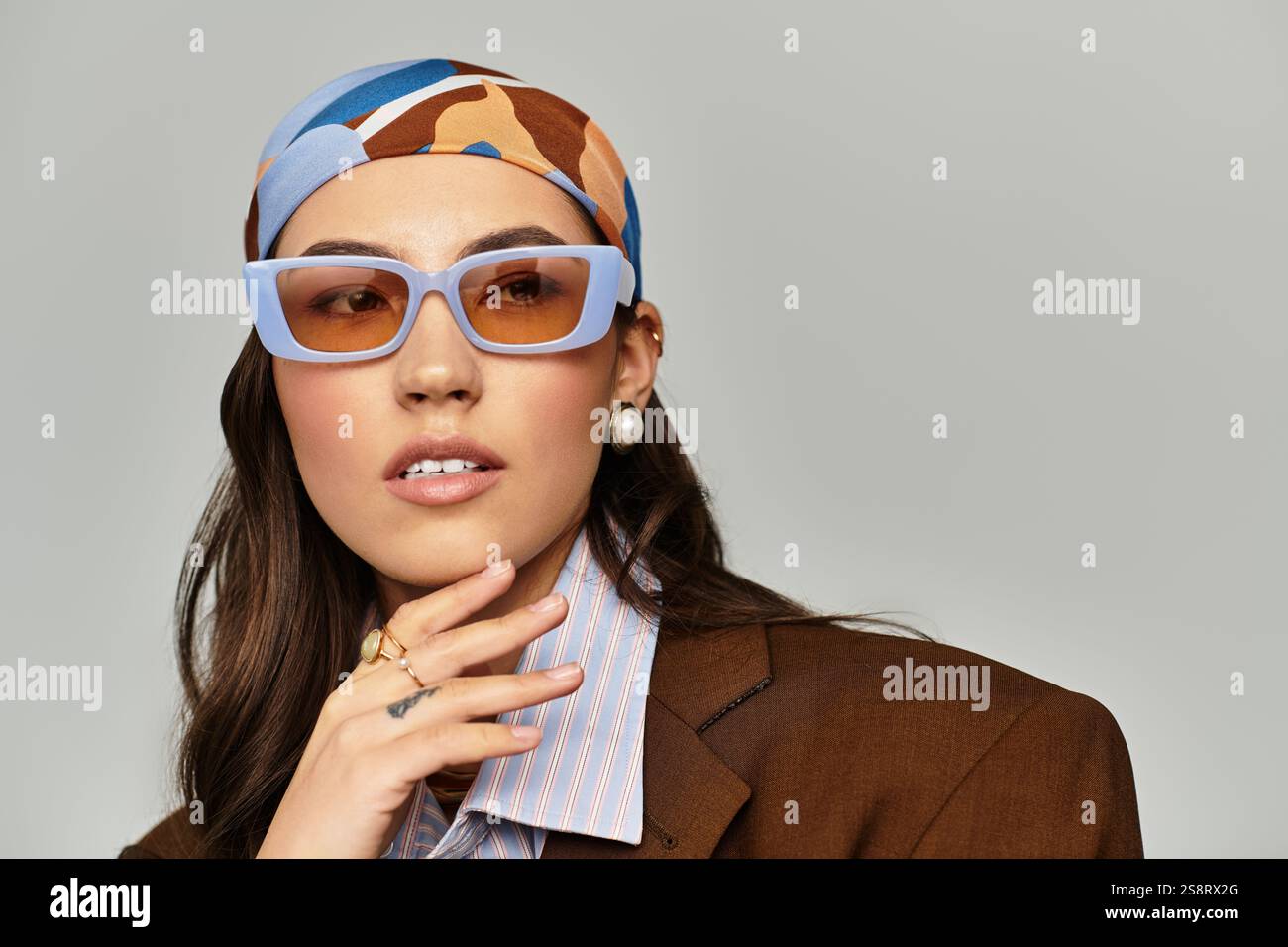 A confident woman models stylish sunglasses and a colorful headscarf ...