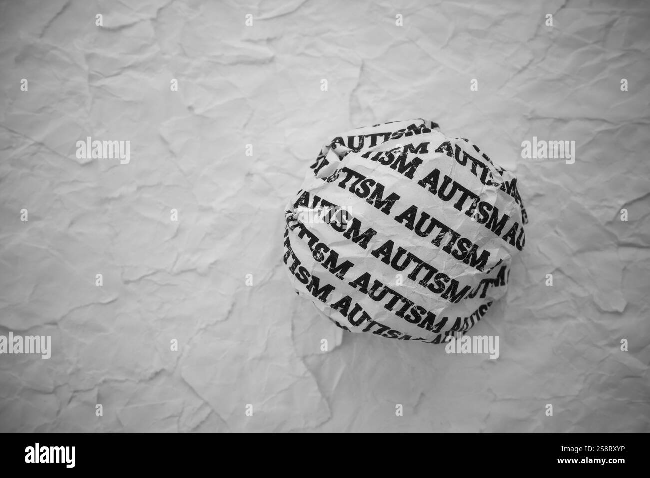 Crumpled paper ball with words Autism on torn white paper pieces ...