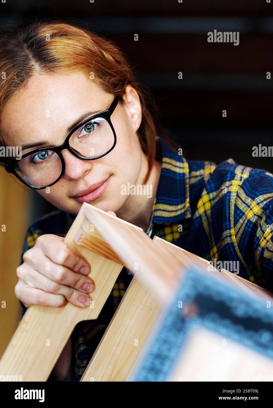 Handywoman measuring wooden crate with angle ruler Stock Photo - Alamy