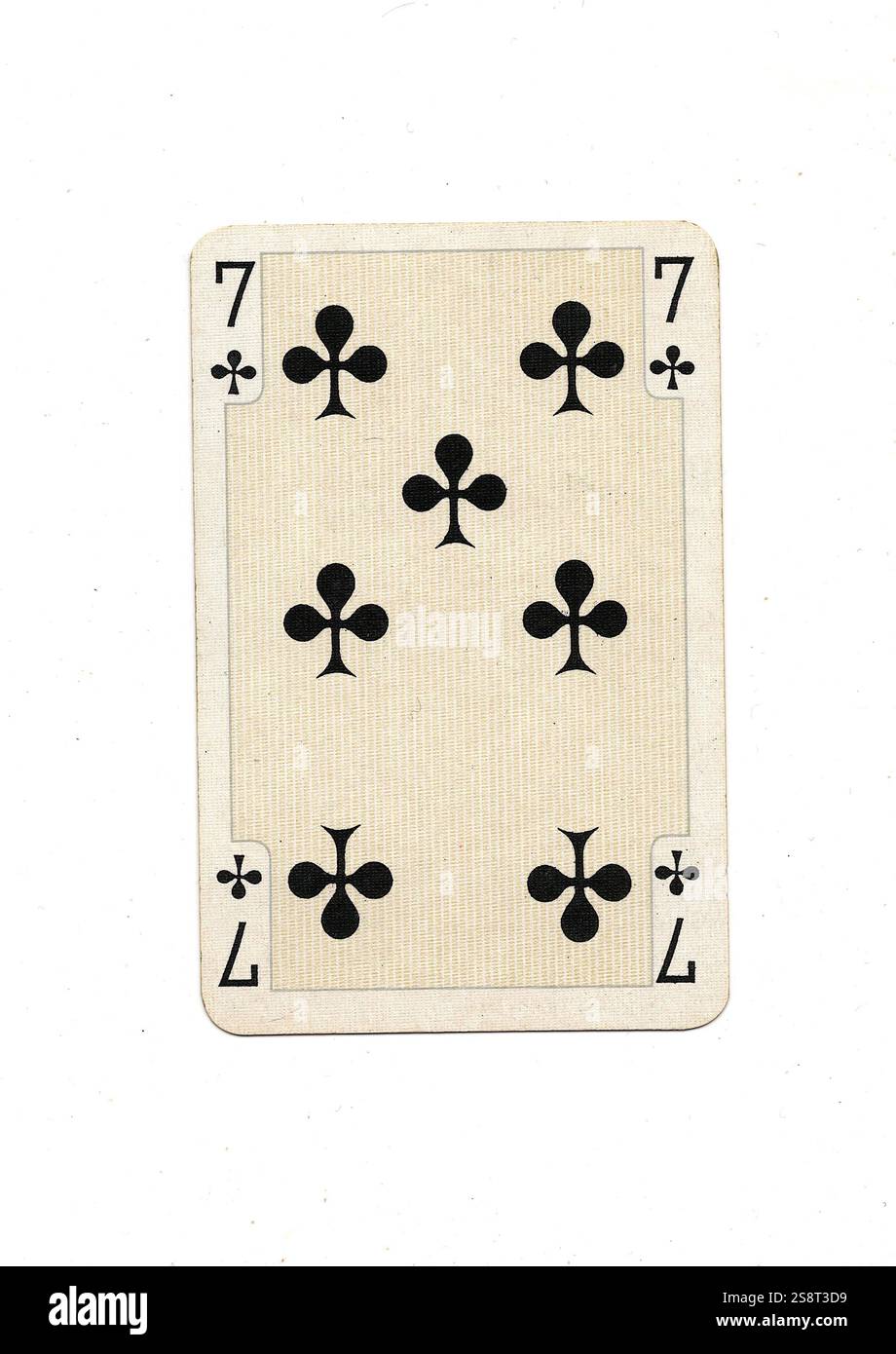 An antique seven of clubs playing card isolated on a white background ...