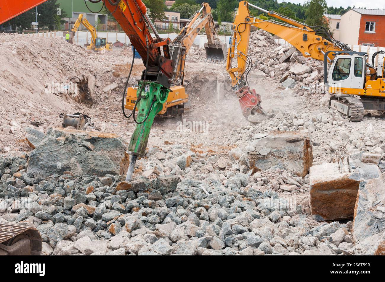 Demolition site. Three excavators in action equipped with different ...