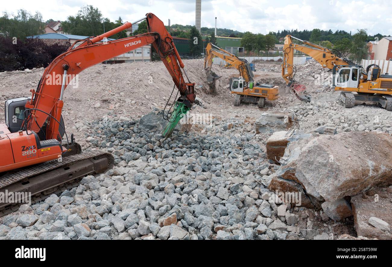 Demolition site. Four excavators in action equipped with different ...