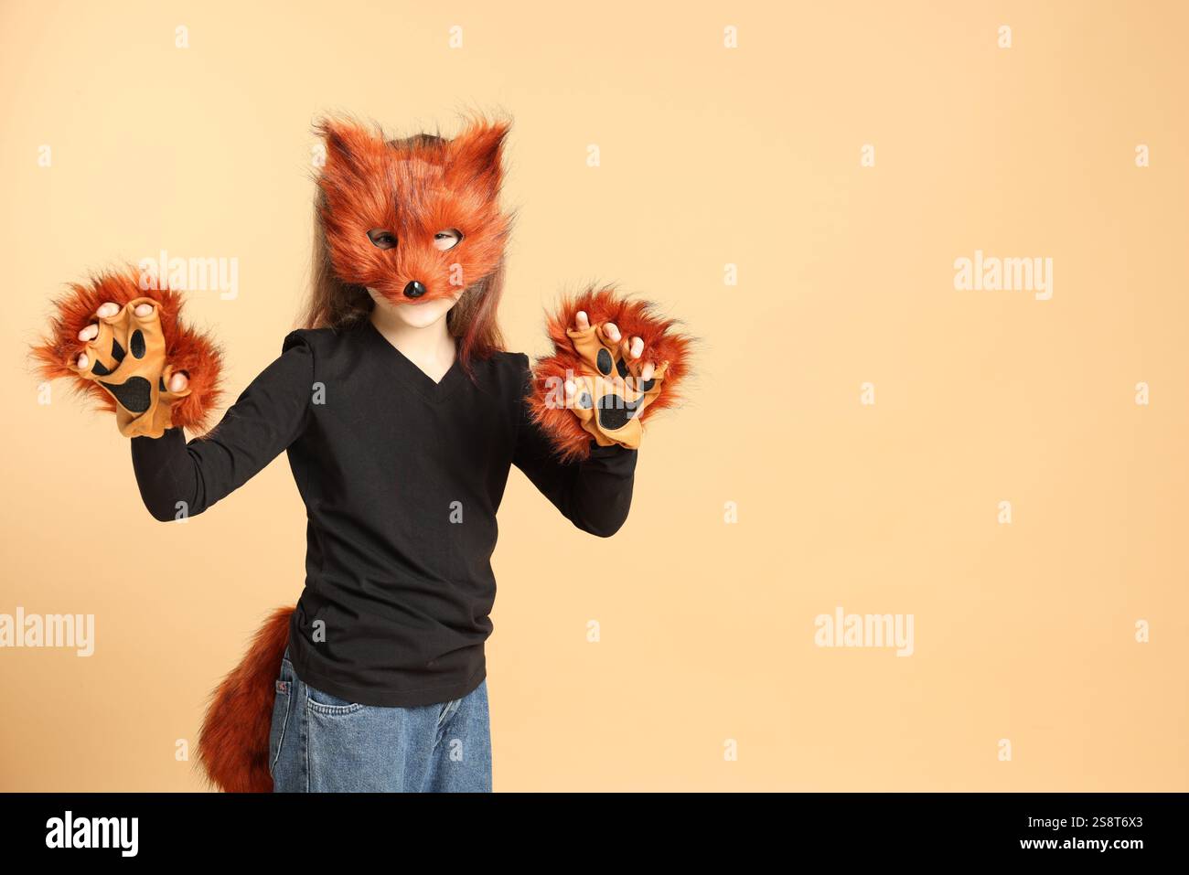 Quadrobics. Girl wearing fox mask, tail and gloves on beige background ...