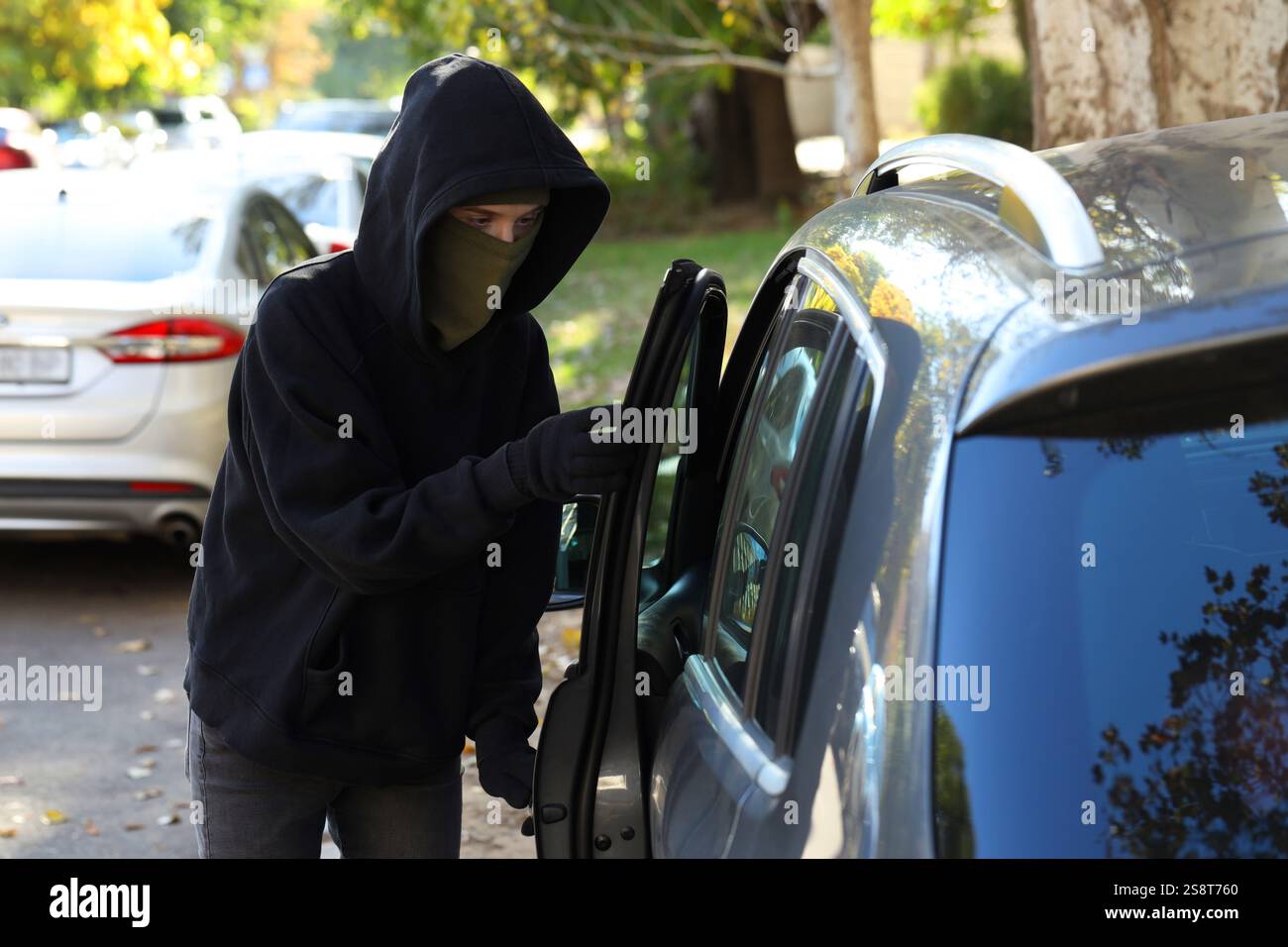 Thief breaking into modern auto. Car hijacking Stock Photo - Alamy