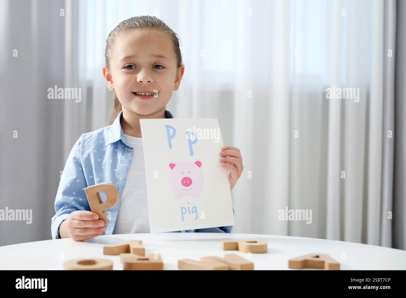 Learning alphabet. Little girl with wooden letter P and picture at ...