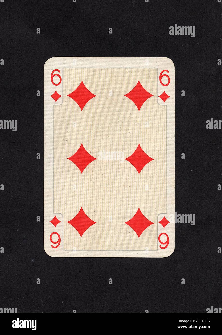An antique six of diamonds playing card isolated on a black background ...