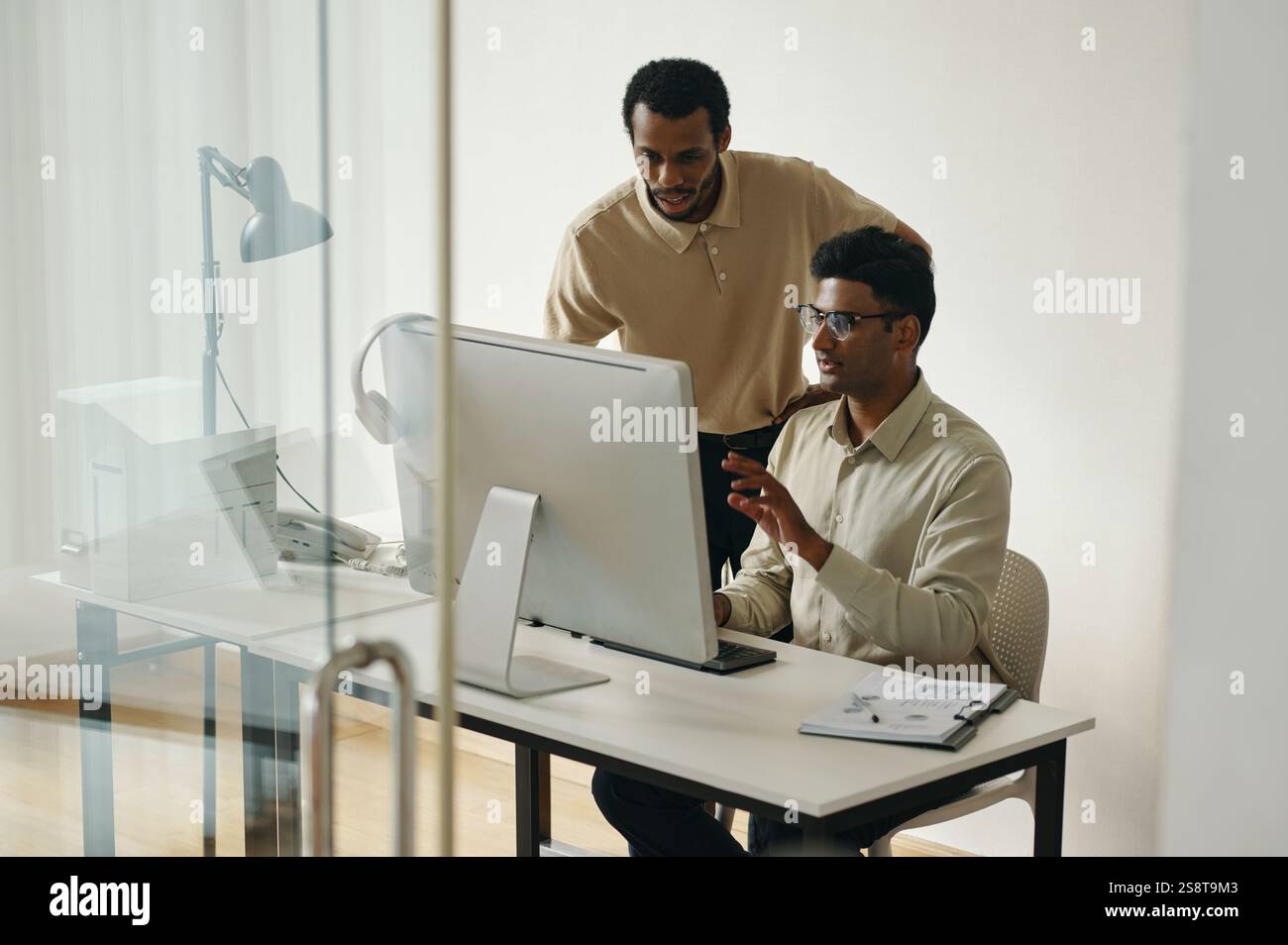 Partners discussing online presentation on computer monitor during ...