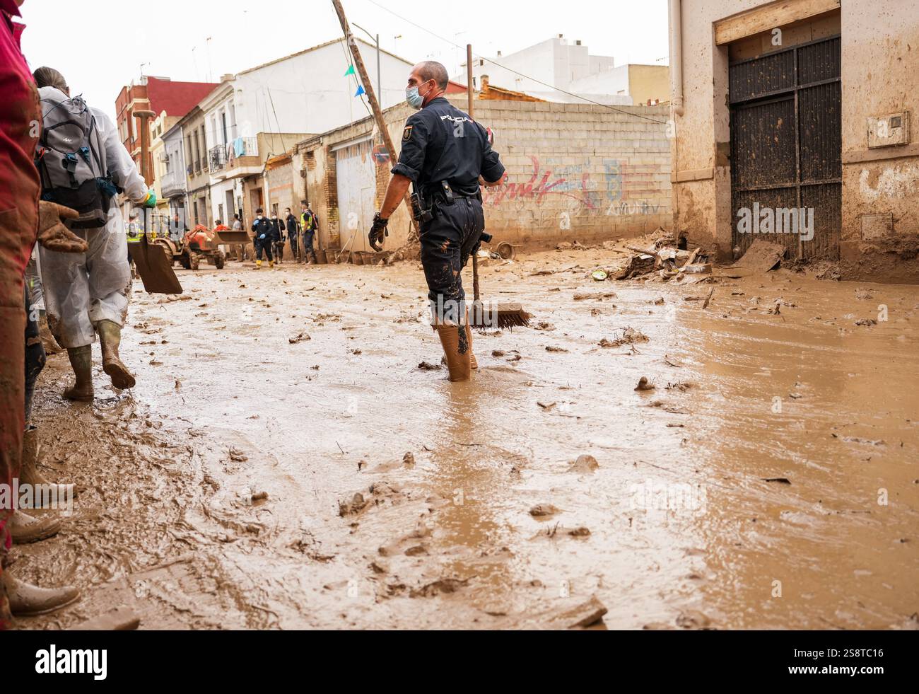 National Police Corps member sinking and covered in mud during cleanup ...