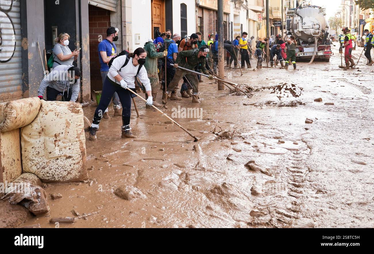 Huge crowd of people working at mud removal from a flooded street after ...