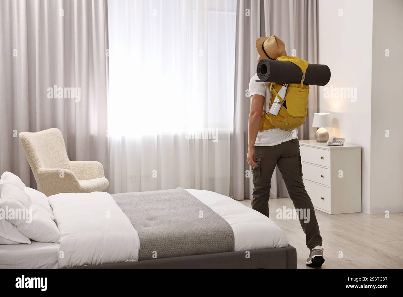 Traveller with backpack in hotel room, back view Stock Photo - Alamy