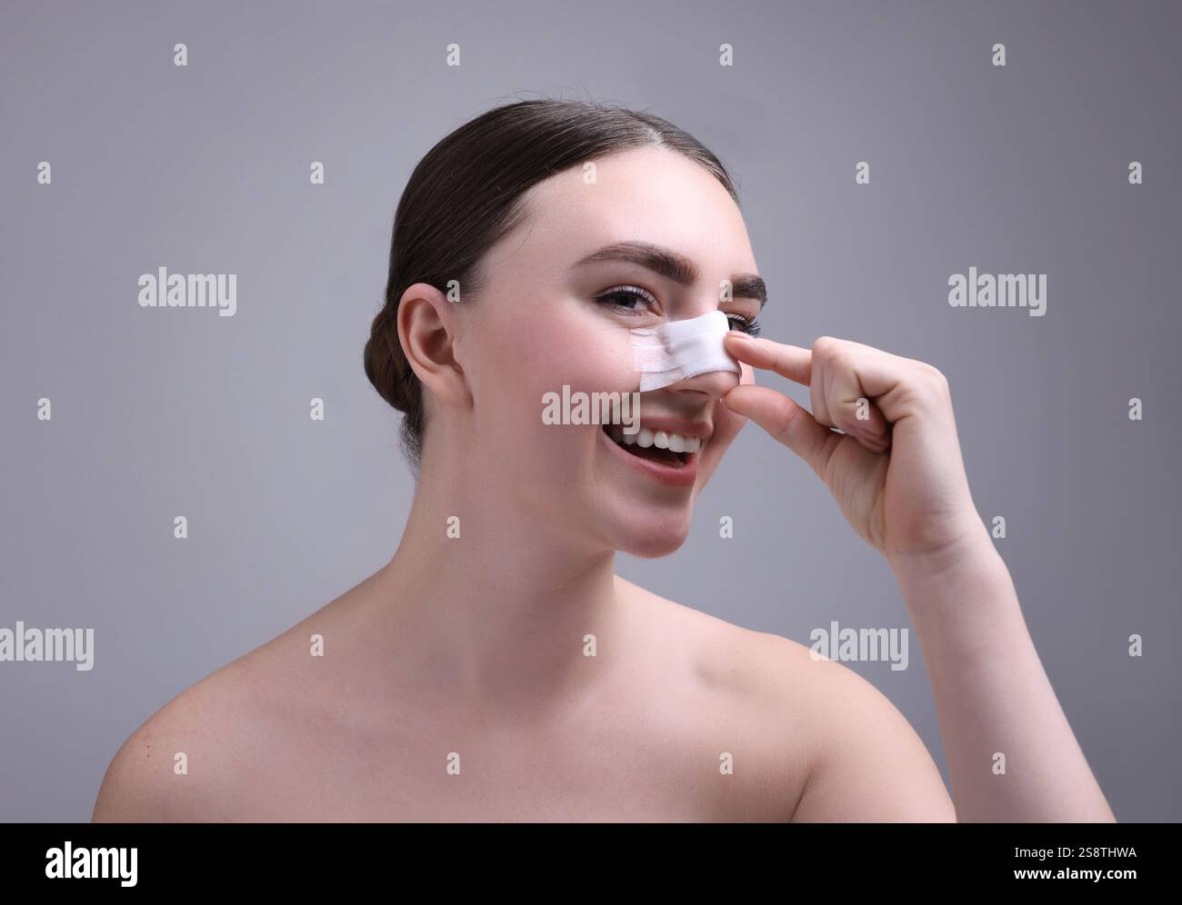 Woman with medical bandage on her nose after plastic surgery operation ...