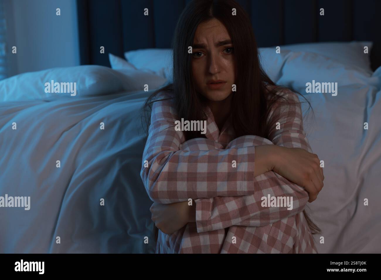 Fear of darkness. Scared young woman in bedroom at night Stock Photo ...