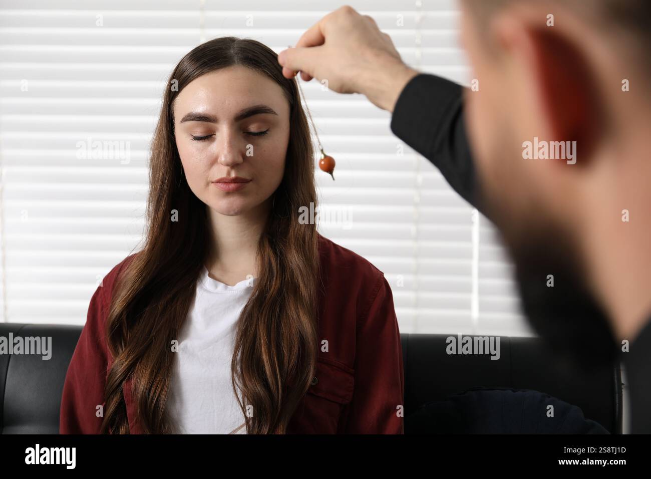 Psychologist using pendulum while working with patient during hypnosis ...
