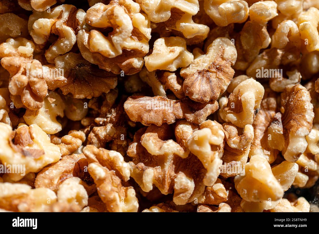 A detailed close-up of shelled walnuts, showcasing their rich texture ...