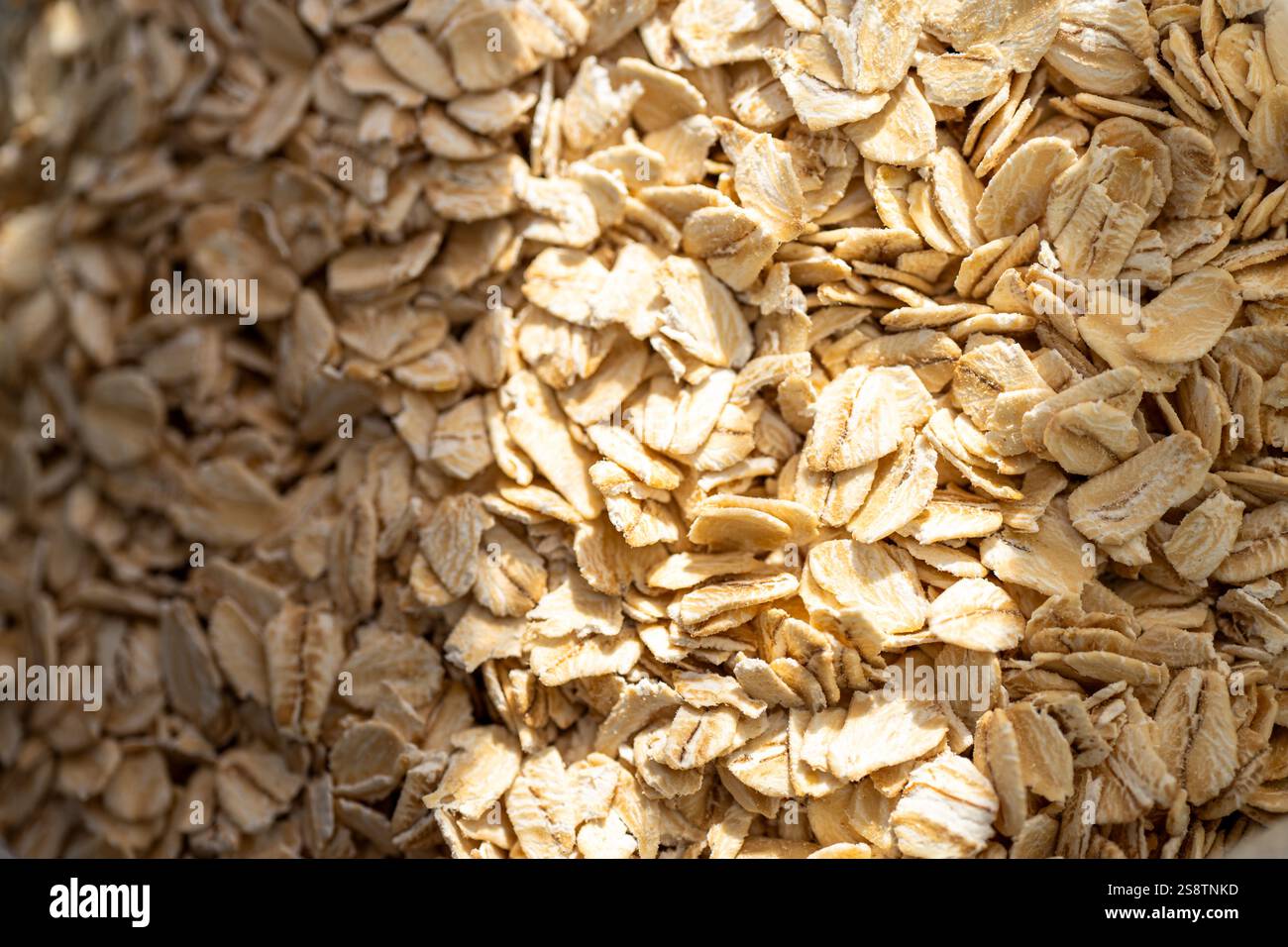 A close-up of raw rolled oats, highlighting their natural texture and ...