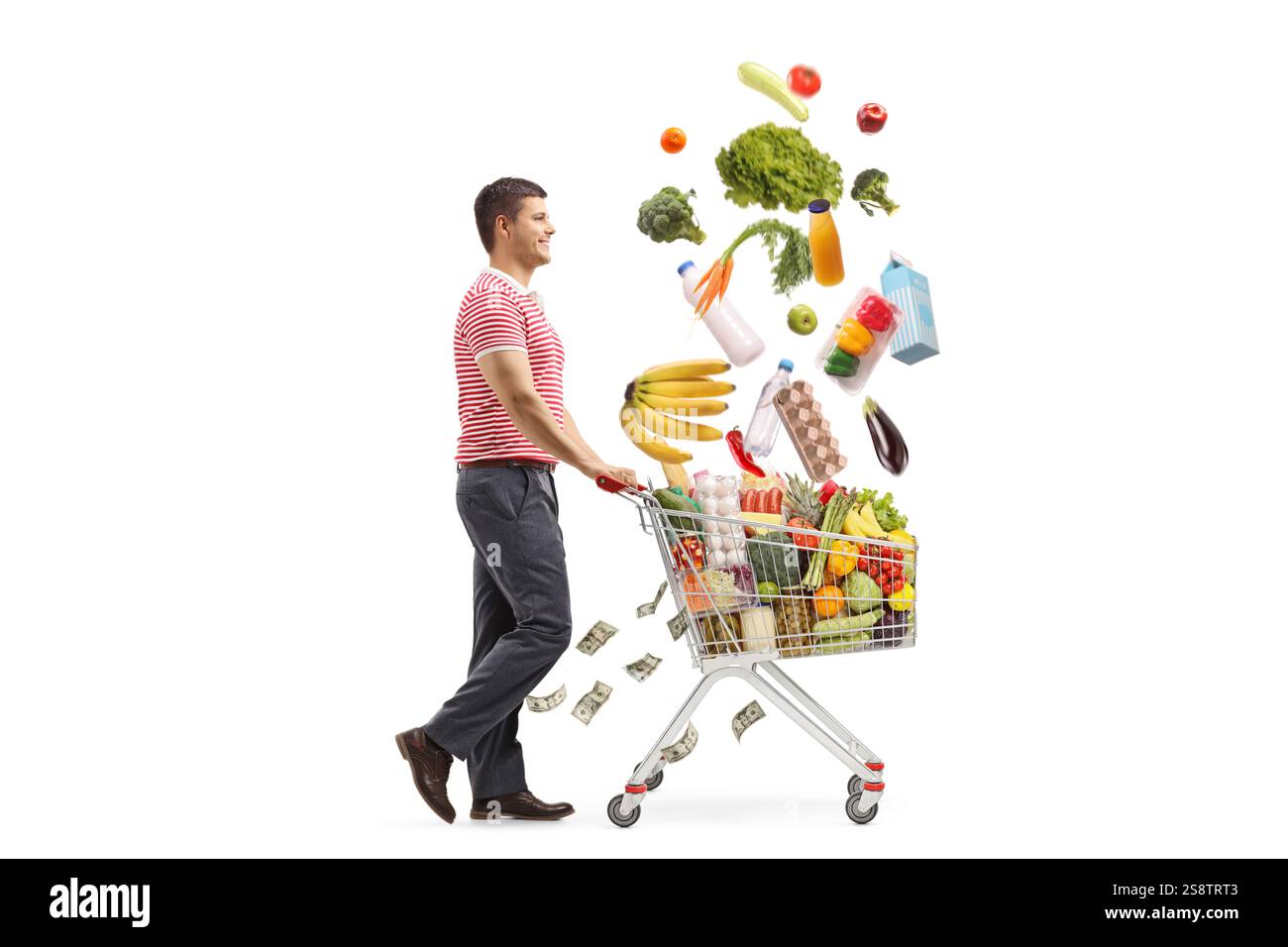 Full length profile shot of a young man walking and pushing a shopping ...