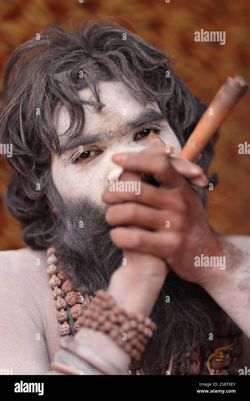 Naga sadhu smoking in an akhara, Maha Kumbh Mela, Prayagraj, Uttar Pradesh, India. Hindu ...