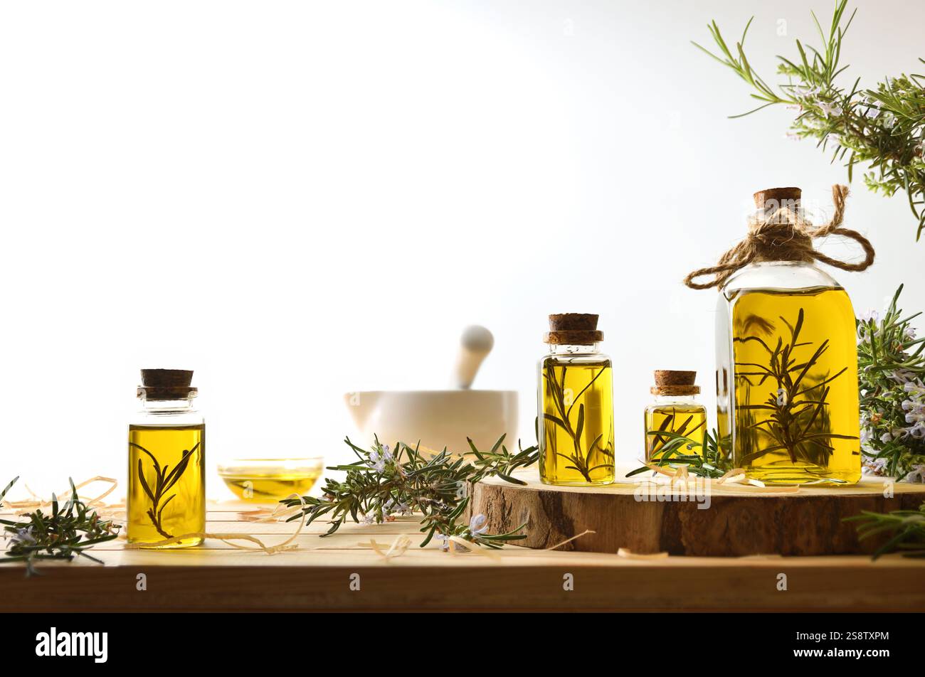 Detail of rosemary oil in a glass bottle prepared at home with twigs on ...