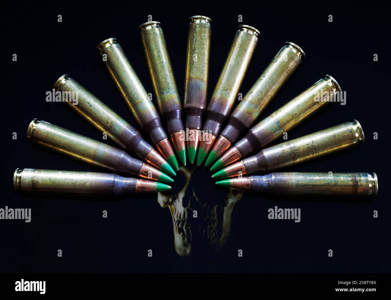 Dark background with a semi-circle of rifle cartridges with green ...