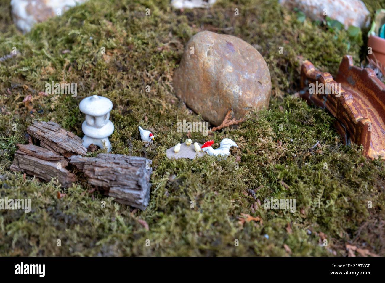 Miniature garden scene with decorative elements on moss-covered ground ...