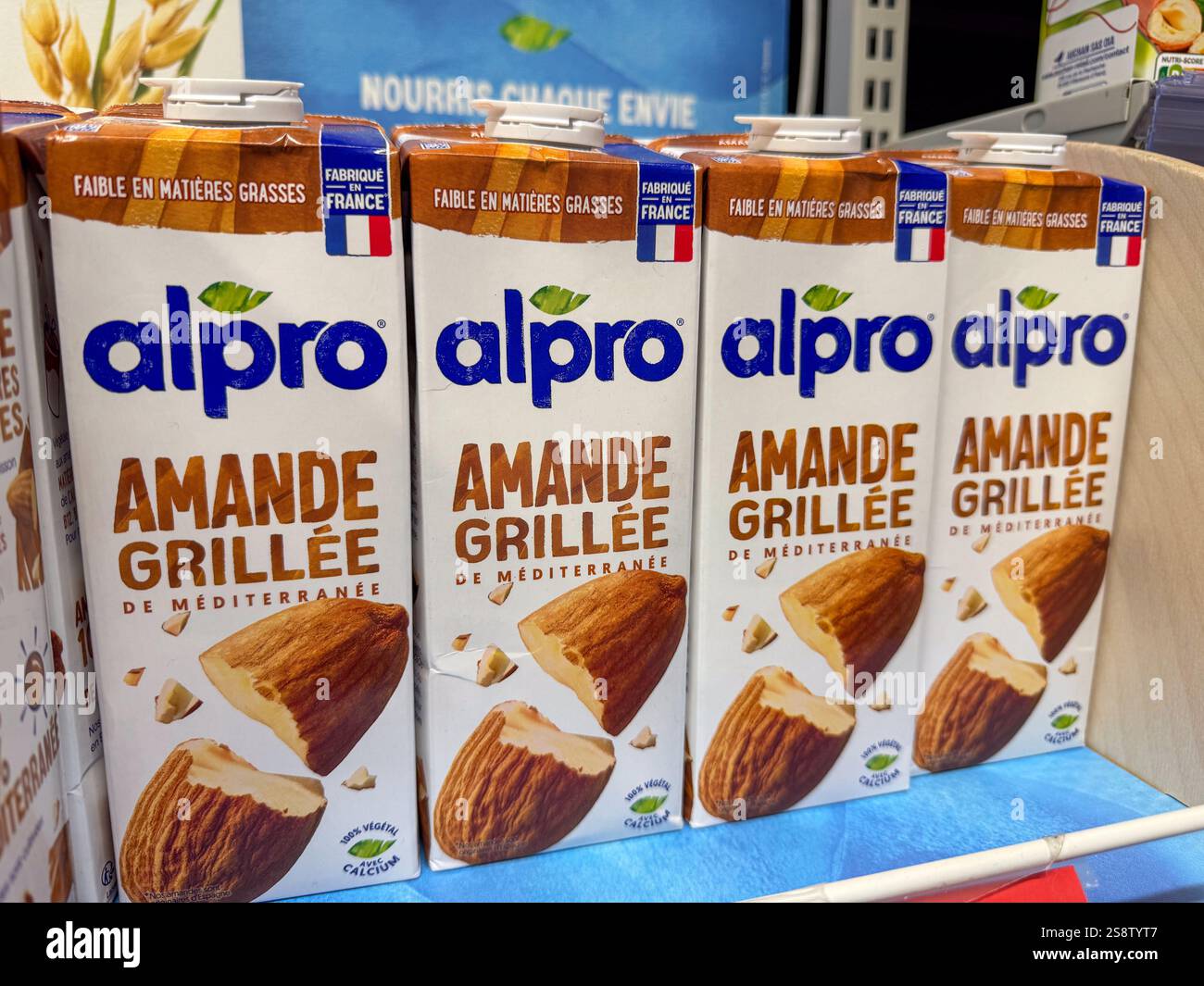 Almond milk cartons neatly lined on a supermarket shelf in a bright ...