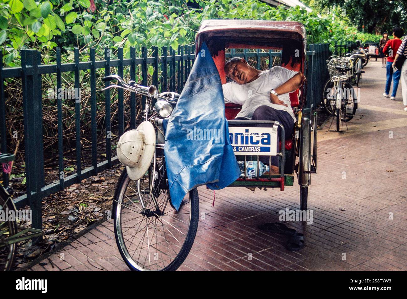 Man sleeping in his rickshaw bike (cycle rickshaw, pedicab), Asian bicycle rickshaw driver ...