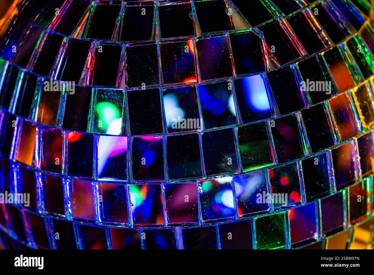Bright shiny mirror disco ball reflecting light in a dark room, close ...