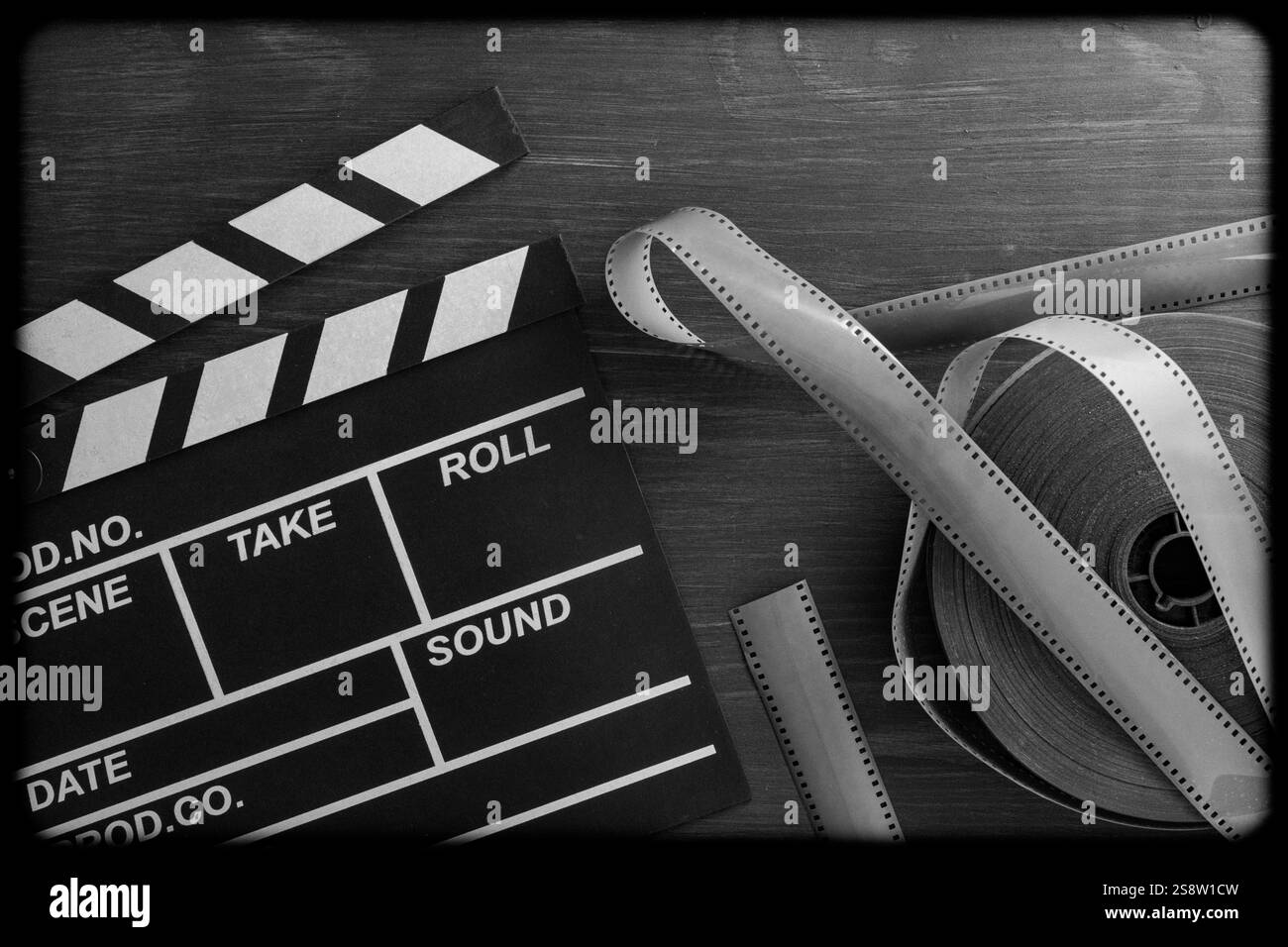 Vintage photo of movie clapper and film strip on wooden background ...