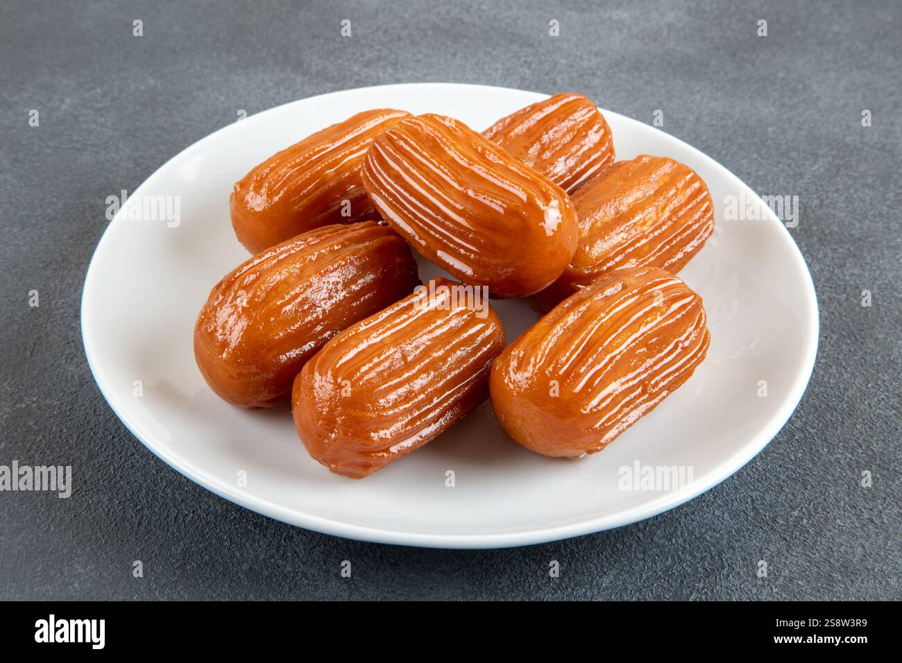 Traditional Turkish dessert tulumba on a plate. Tulumba dessert, fried ...