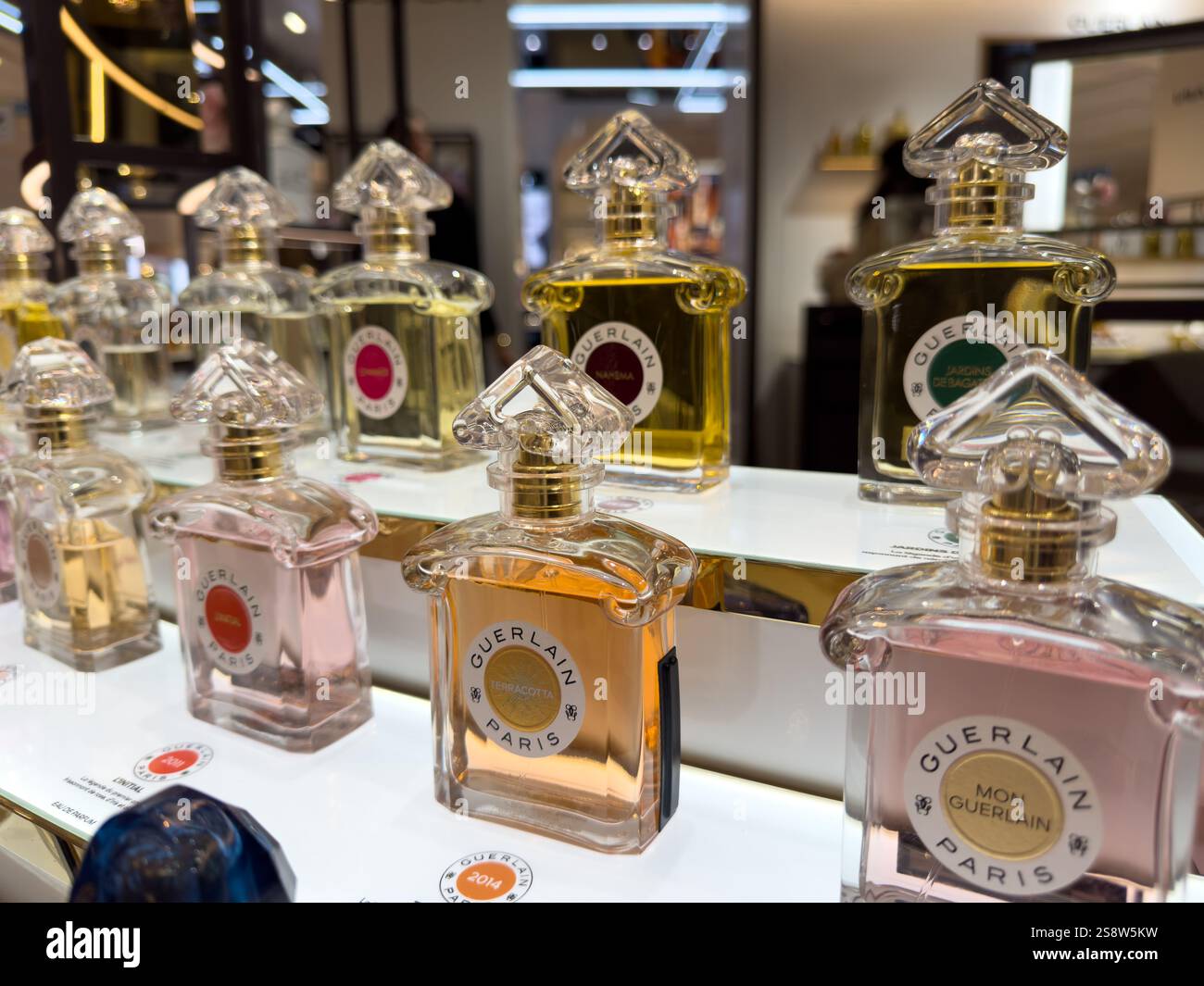 Elegant perfume bottles displayed in a Parisian boutique with soft ...